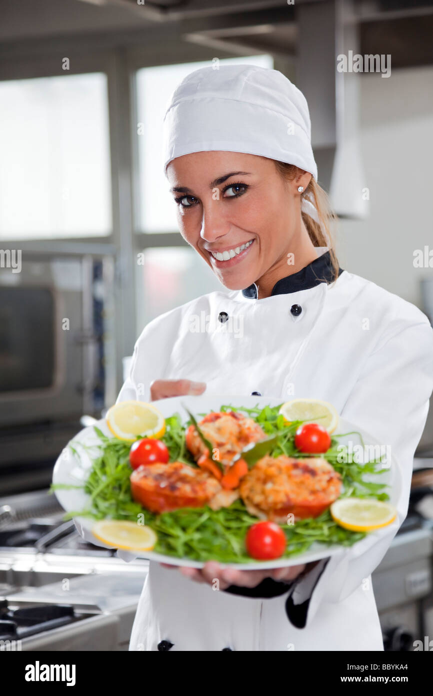 female chef showing dish and looking at camera Stock Photo - Alamy