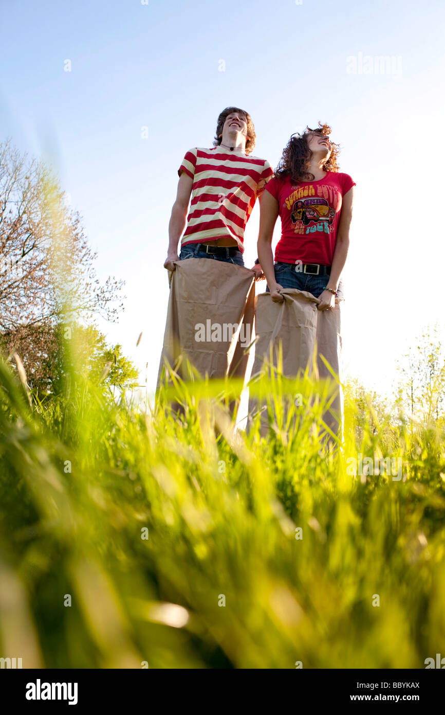 Young couple playing sack race Stock Photo - Alamy