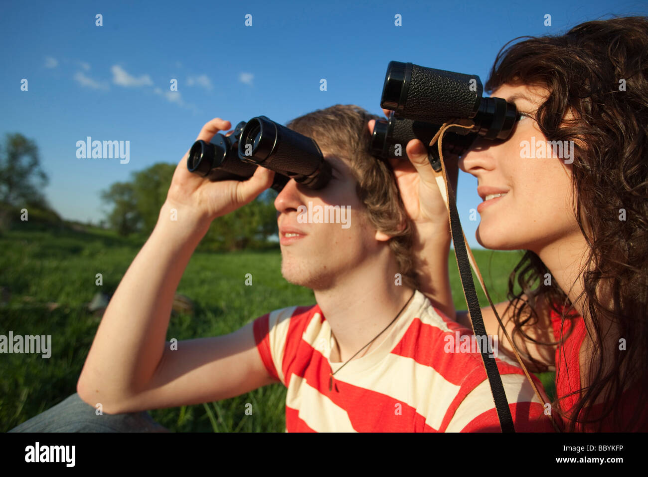 Couple using binoculars Stock Photo - Alamy