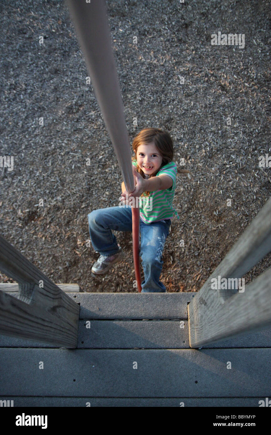 Little girl climbing rope at playground Stock Photo - Alamy