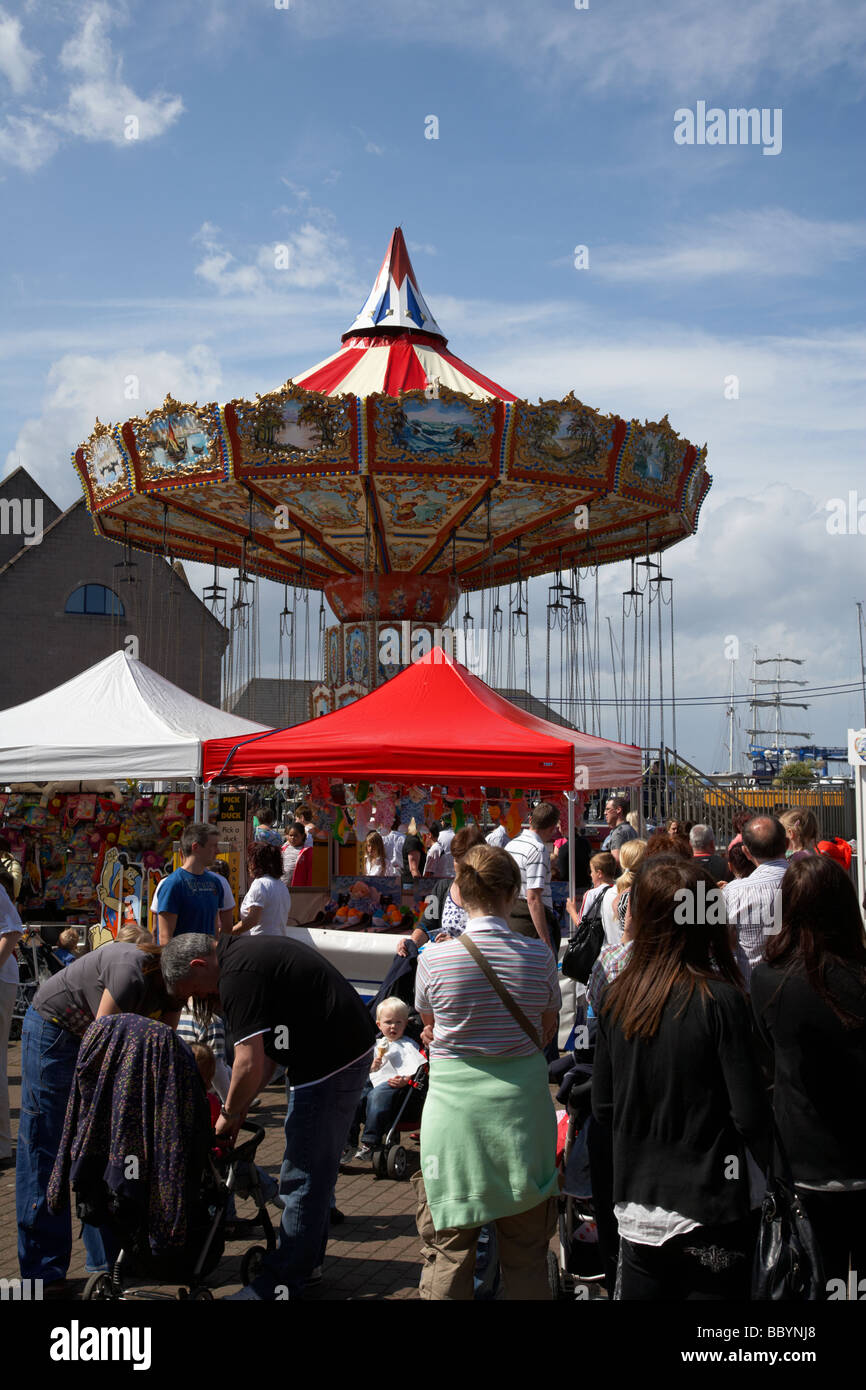 crowd walking through travelling amusment park with chair o plane ...