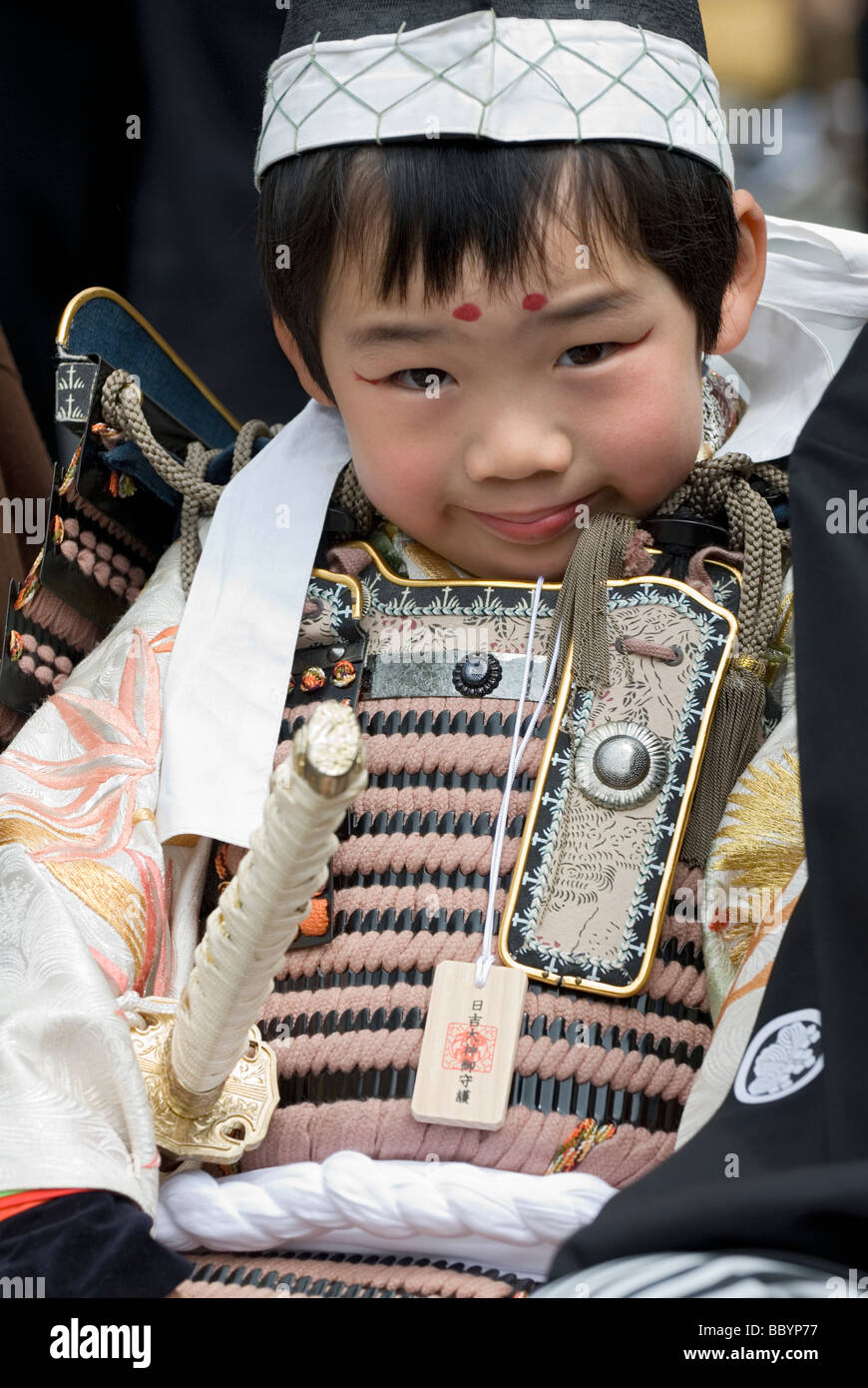 A young boy dressed up in samurai festival attire complete with sword ...