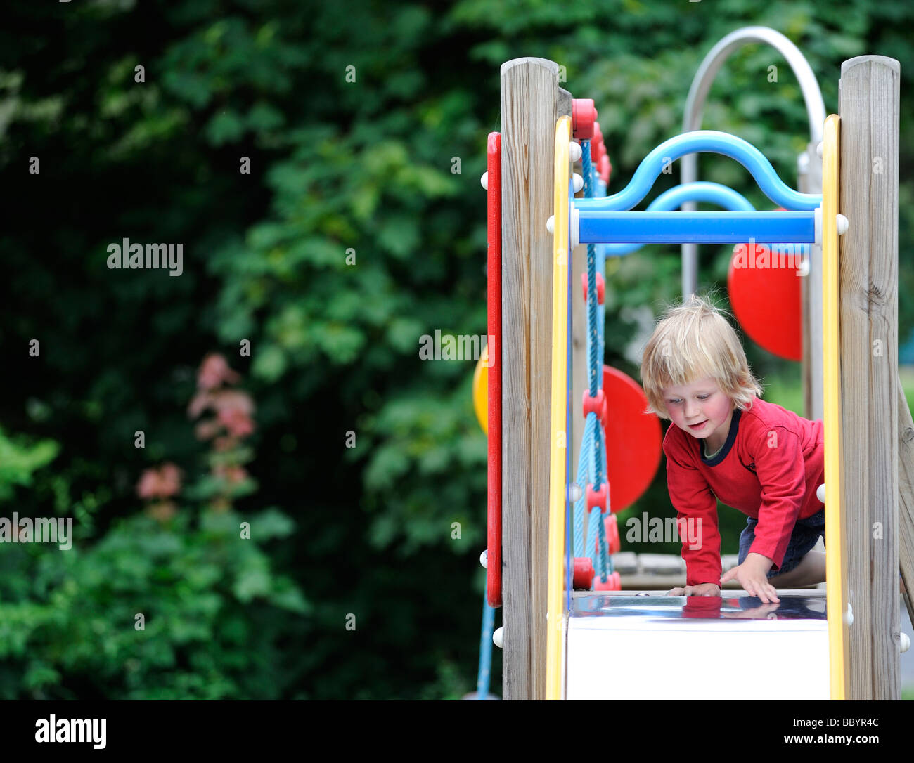 Child blonde boy sliding down the slide on the playground Stock Photo ...