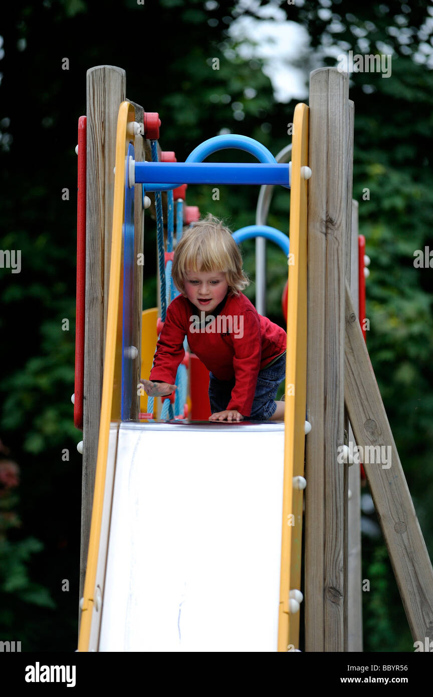 Child blonde boy sliding down the slide on the playground Stock Photo ...