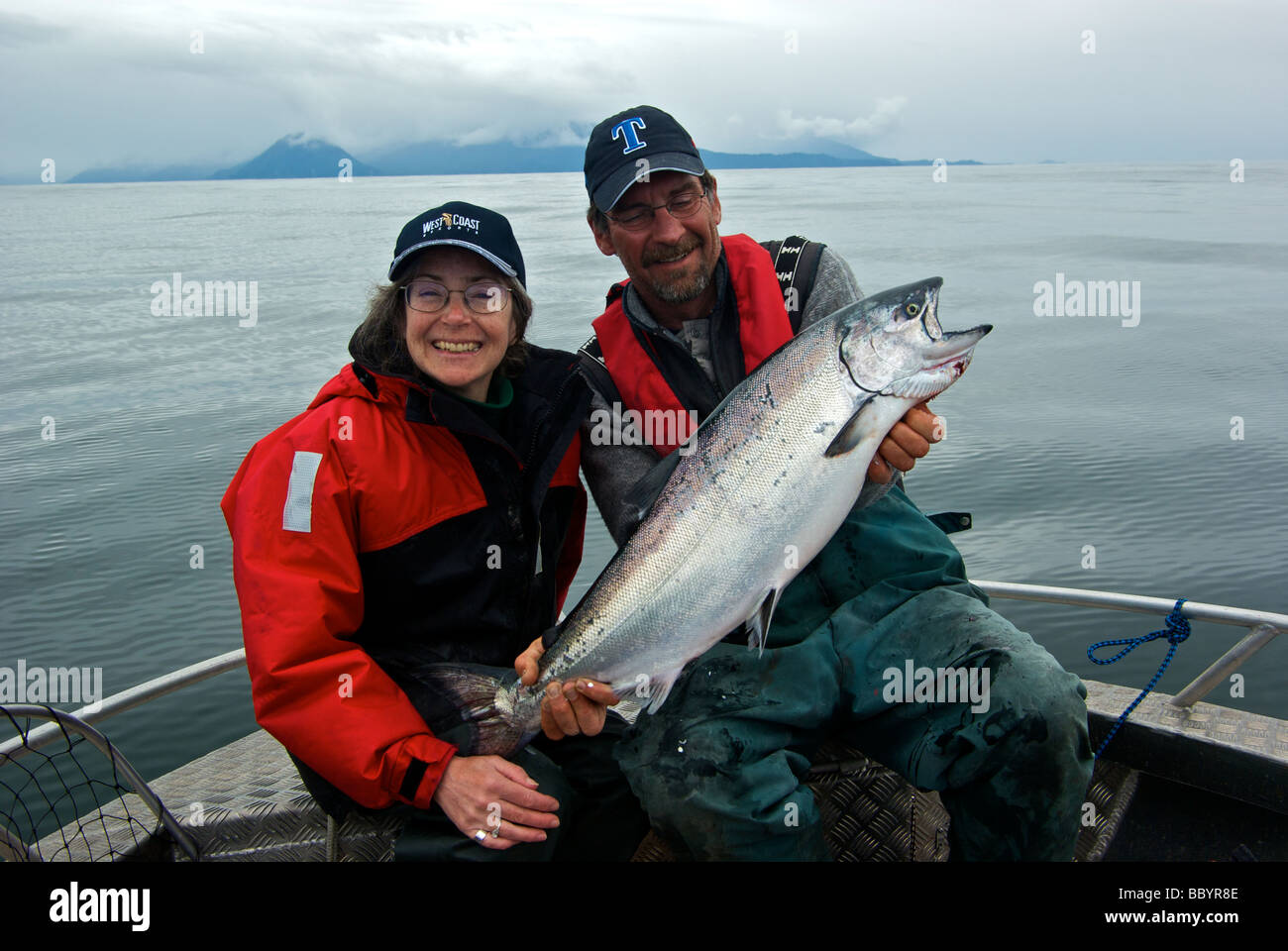 Smiling woman angler with her fishing guide holding a fine bright Haida ...