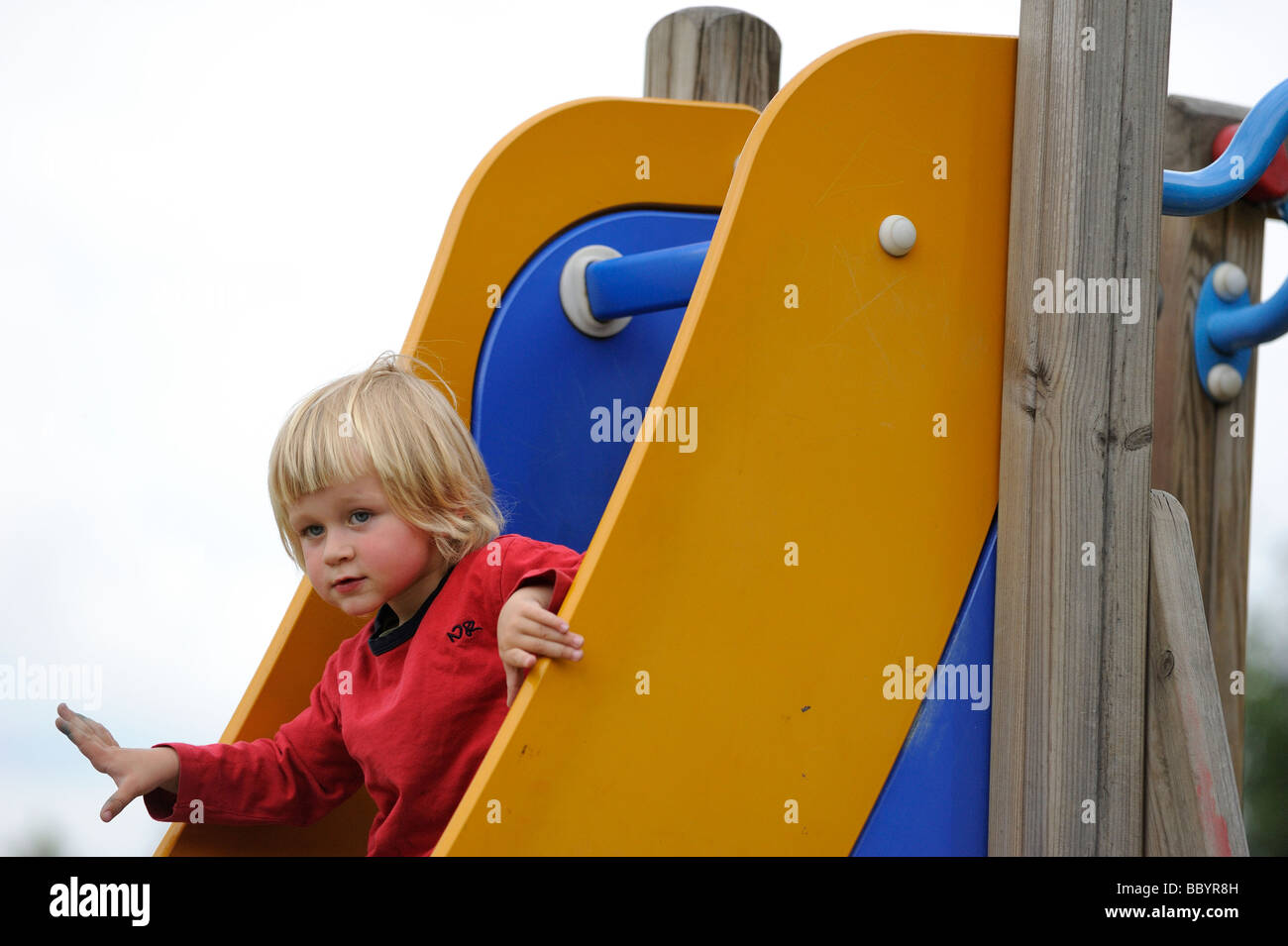 Child blonde boy sliding down the slide on the playground Stock Photo ...