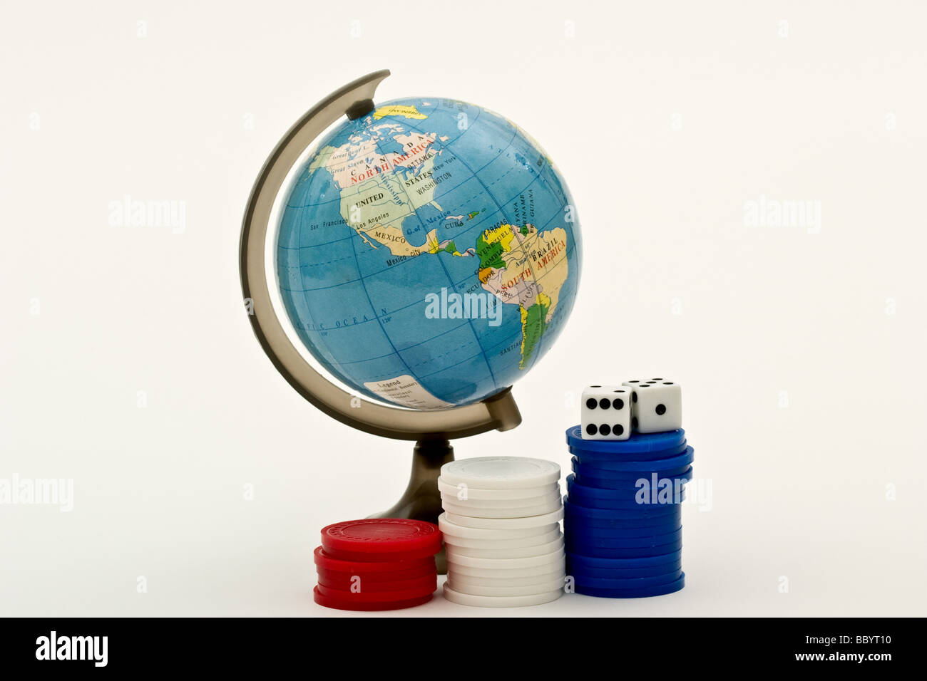Small plastic globe behind three stacks of poker chips, one stack with ...