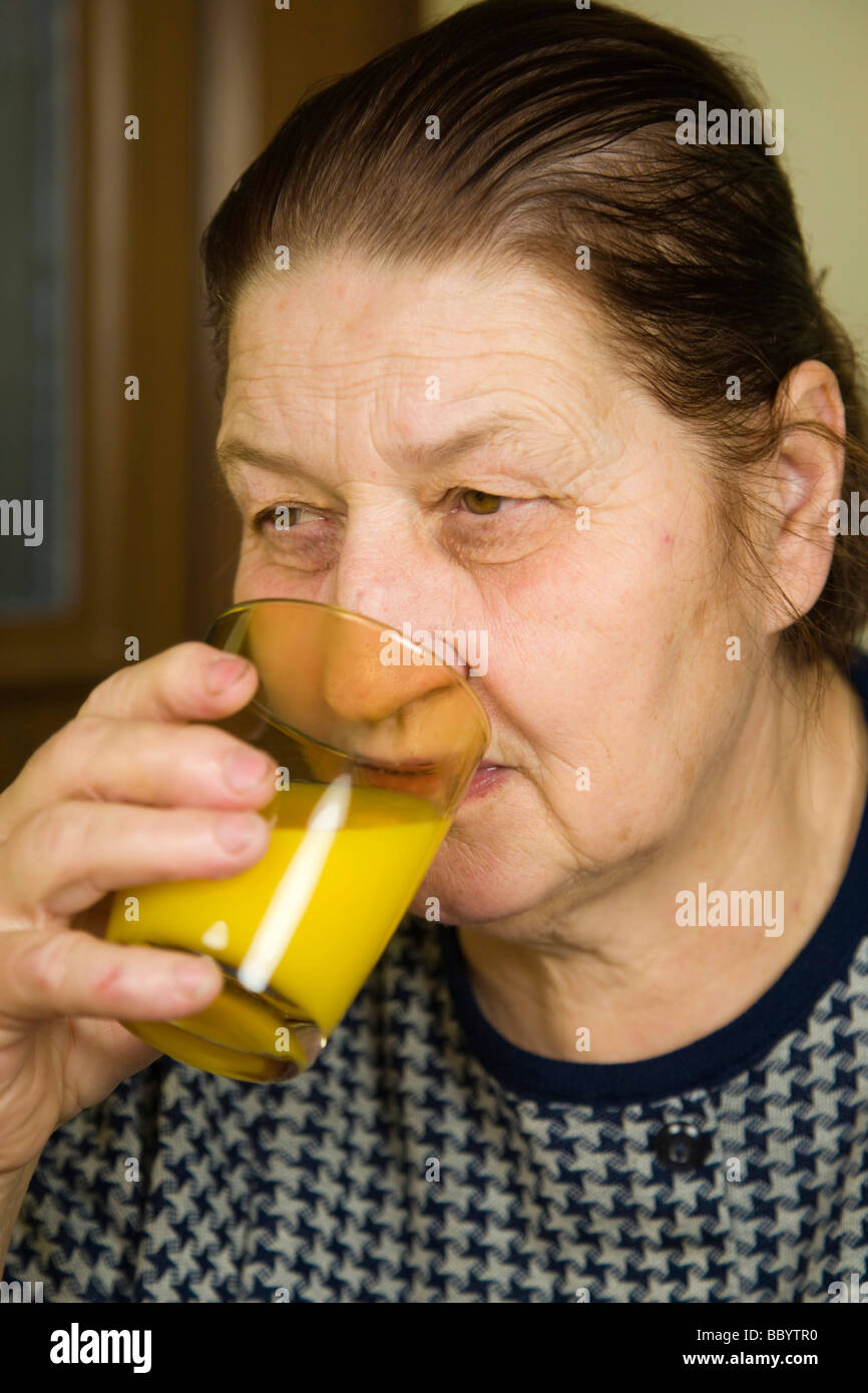 Woman, 67 years old, drinking orange juice Stock Photo - Alamy