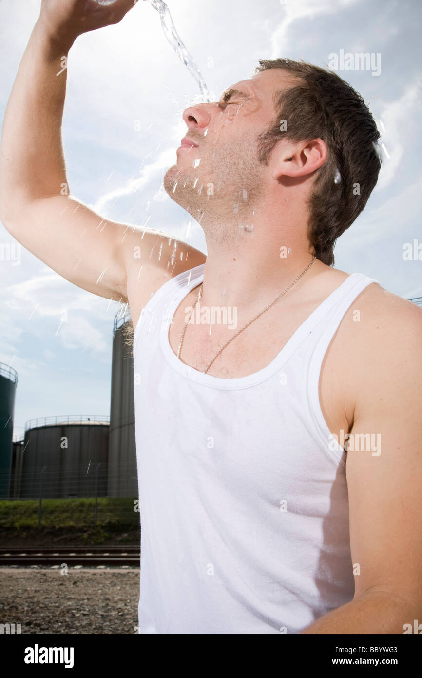 Young man tipping water onto his face Stock Photo - Alamy