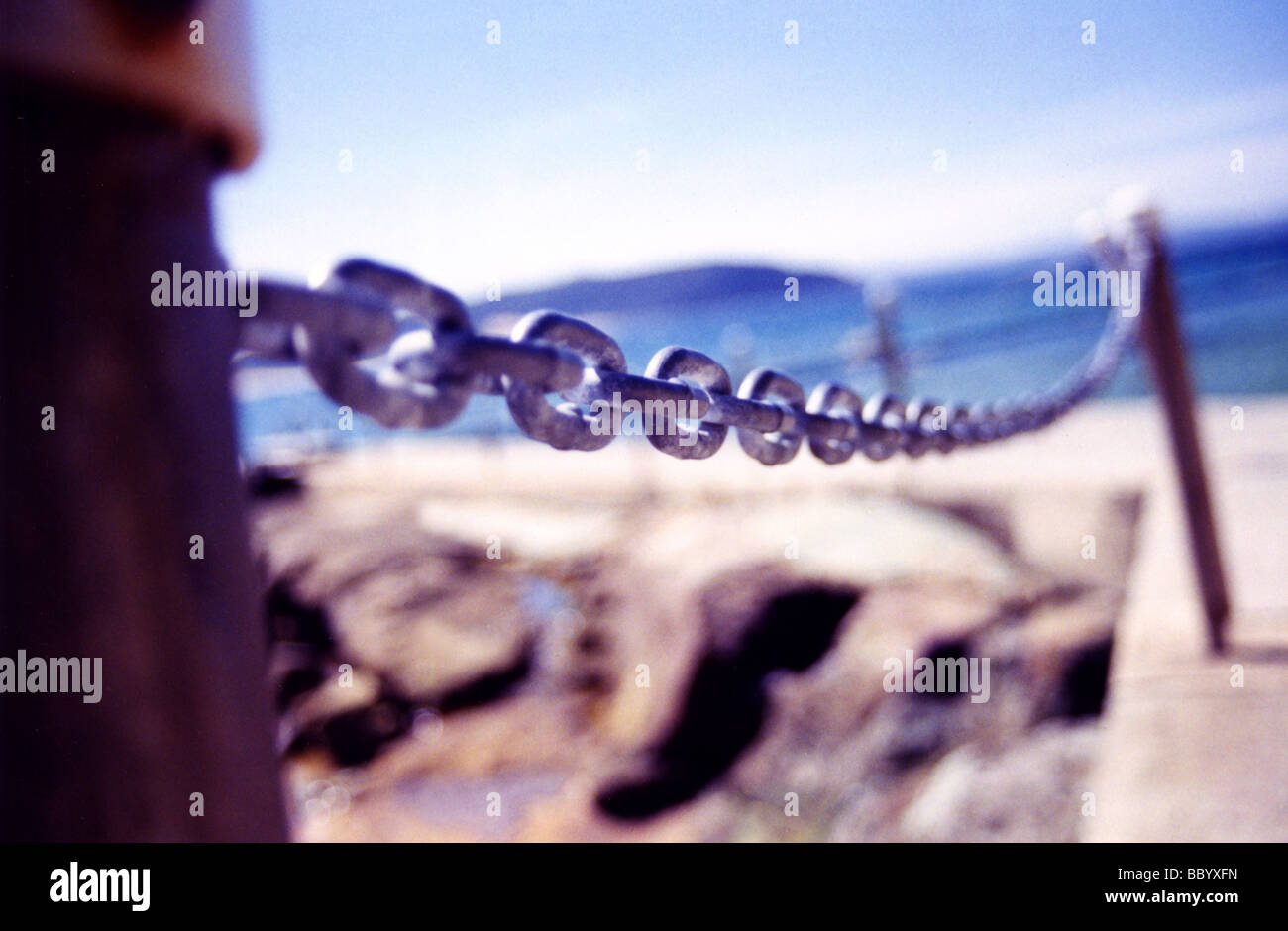 Metal posts and chain along sea wall Stock Photo - Alamy