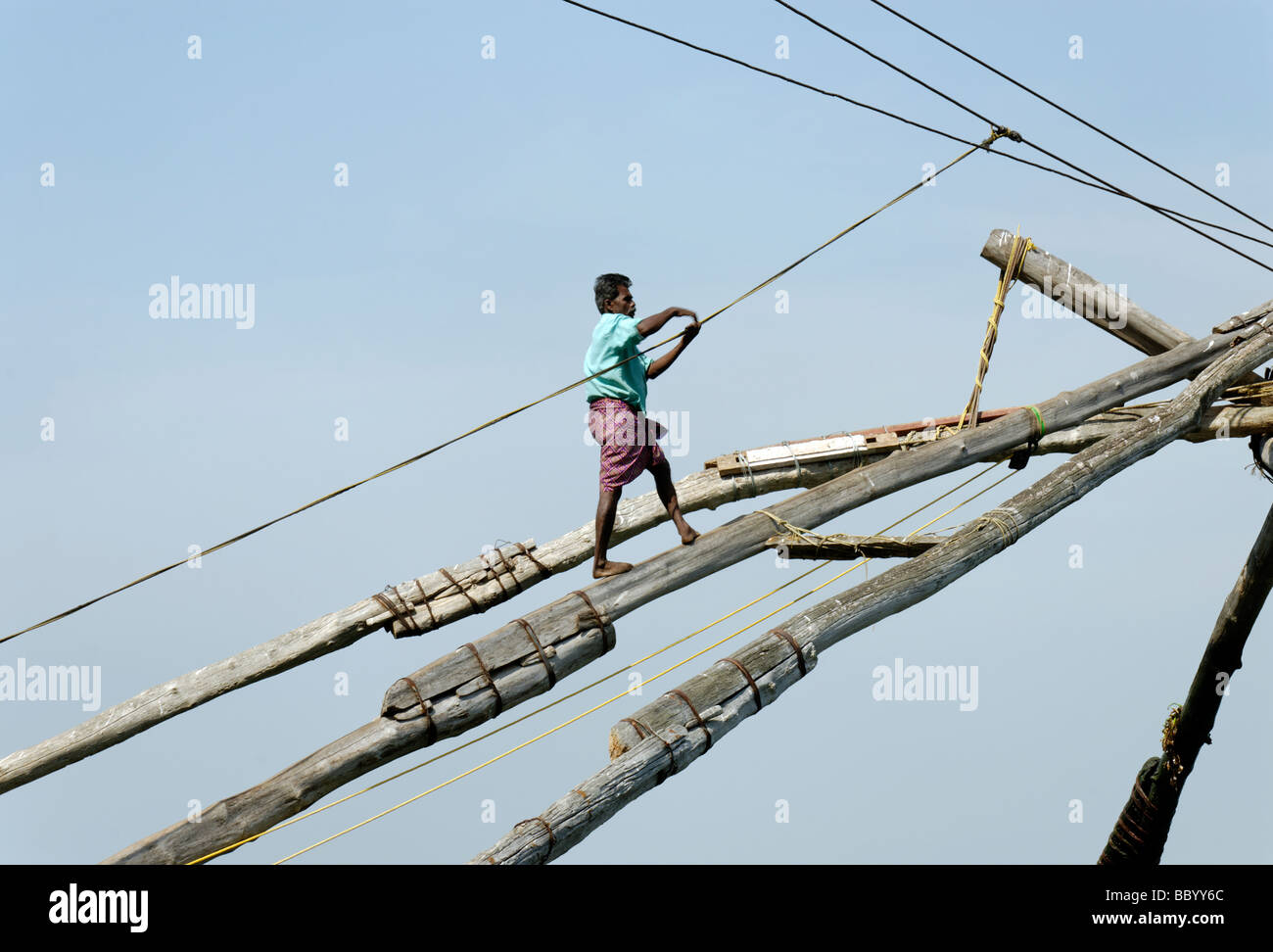 Man climbing a fishing net structure Stock Photo - Alamy