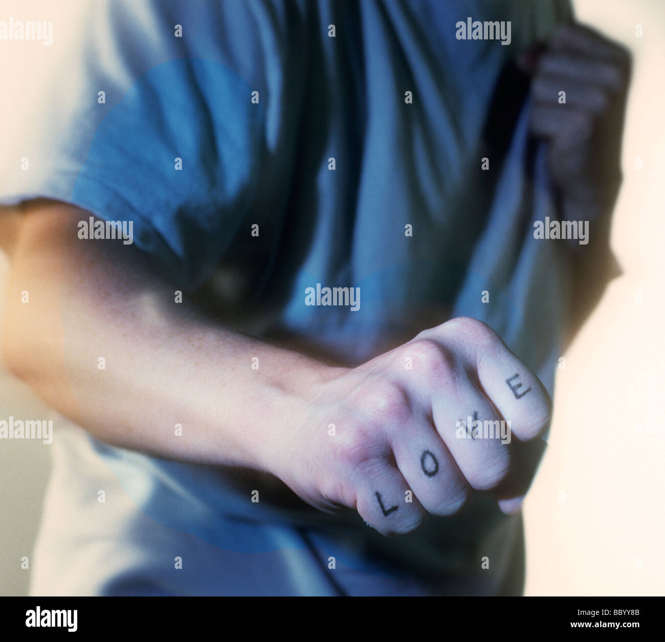 Man with LOVE tattoo throwing a punch Stock Photo - Alamy