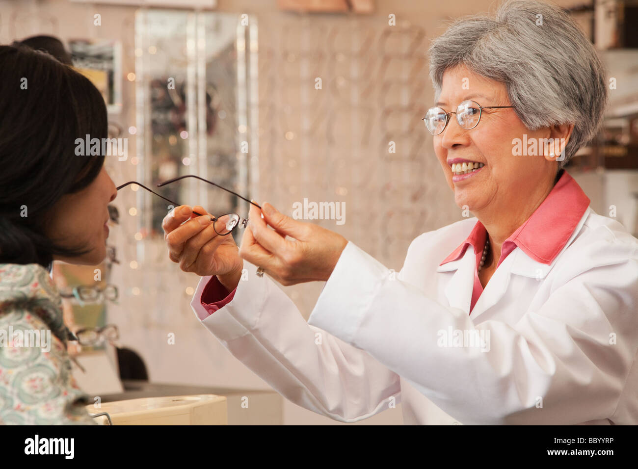 Chinese optician fitting eyeglasses on customer Stock Photo - Alamy