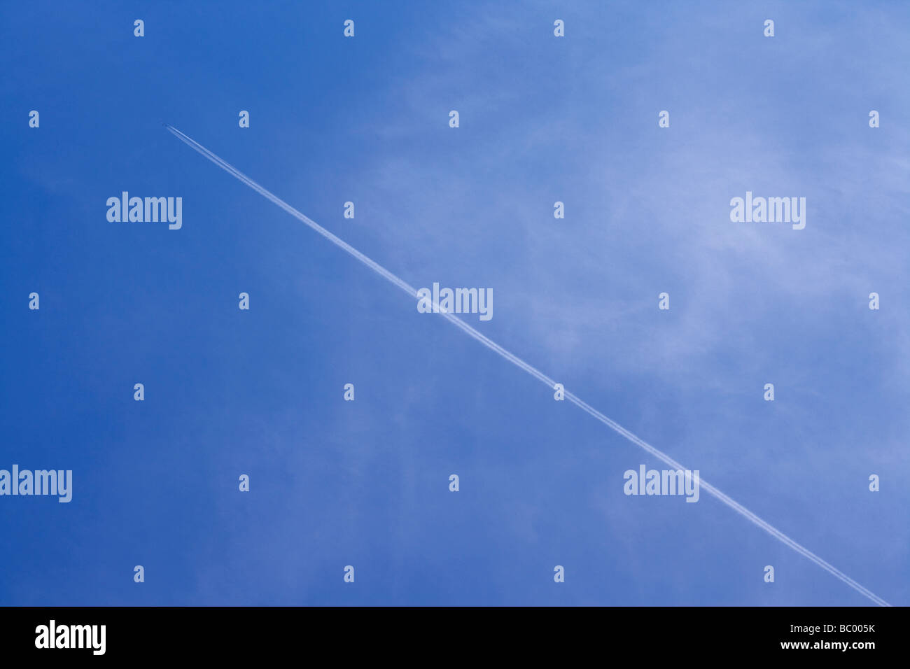 Jet trail across blue sky Stock Photo - Alamy