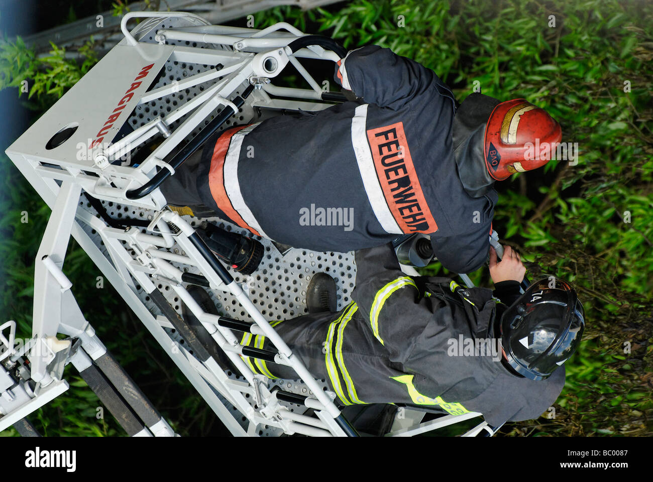 Two firemen in aerial platform of fire engine Stock Photo - Alamy