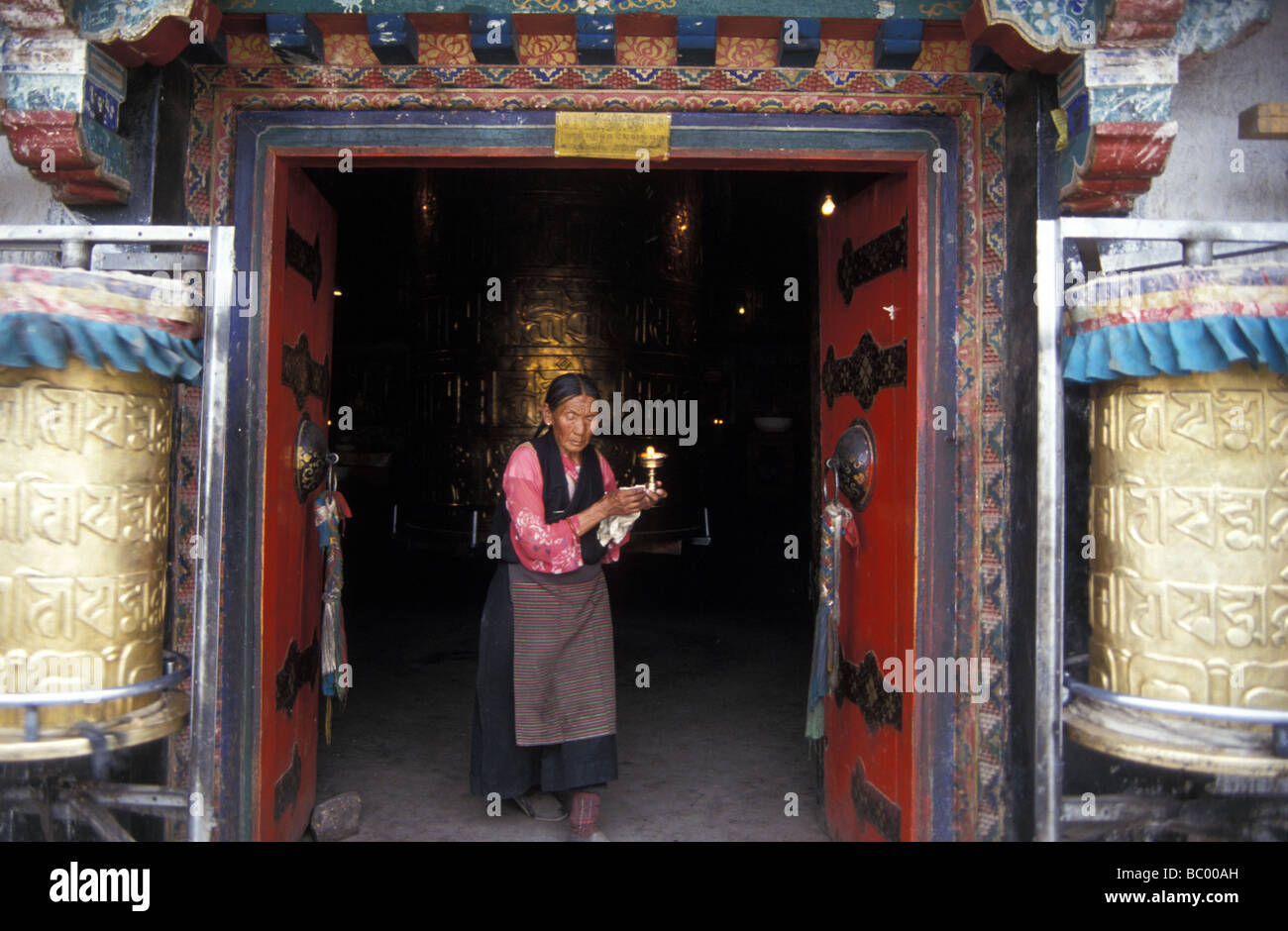 Tibetan pilgrim large Buddhist prayer wheels temple Lhasa capital city ...