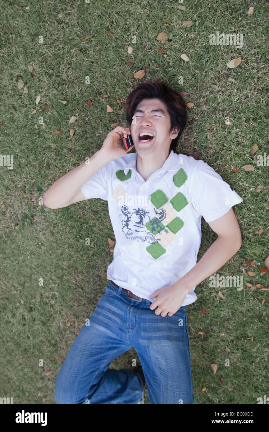 Chinese man laughing and using cell phone Stock Photo - Alamy