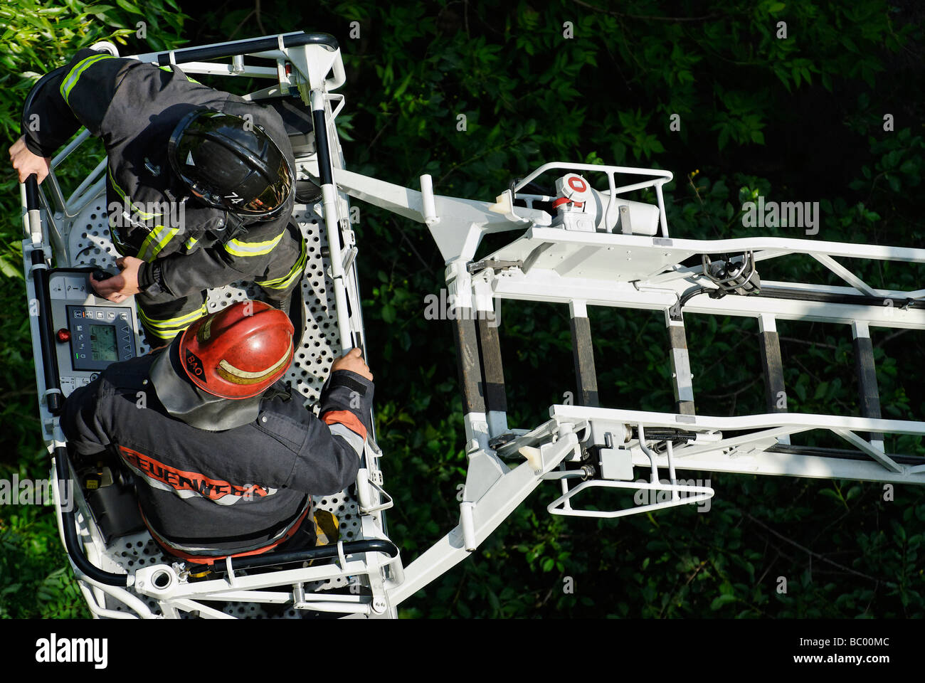 Two firemen in aerial platform of fire engine Stock Photo - Alamy