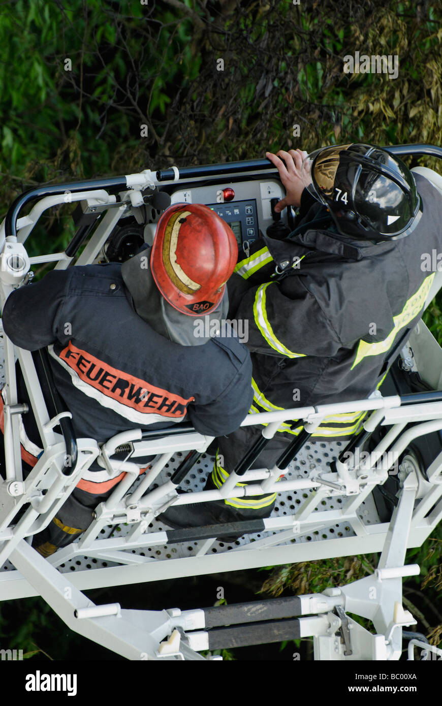 Two firemen in aerial platform of fire engine Stock Photo - Alamy
