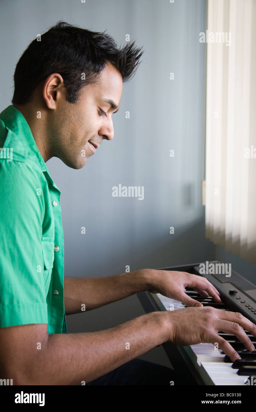 Mixed race man playing electric keyboard Stock Photo - Alamy