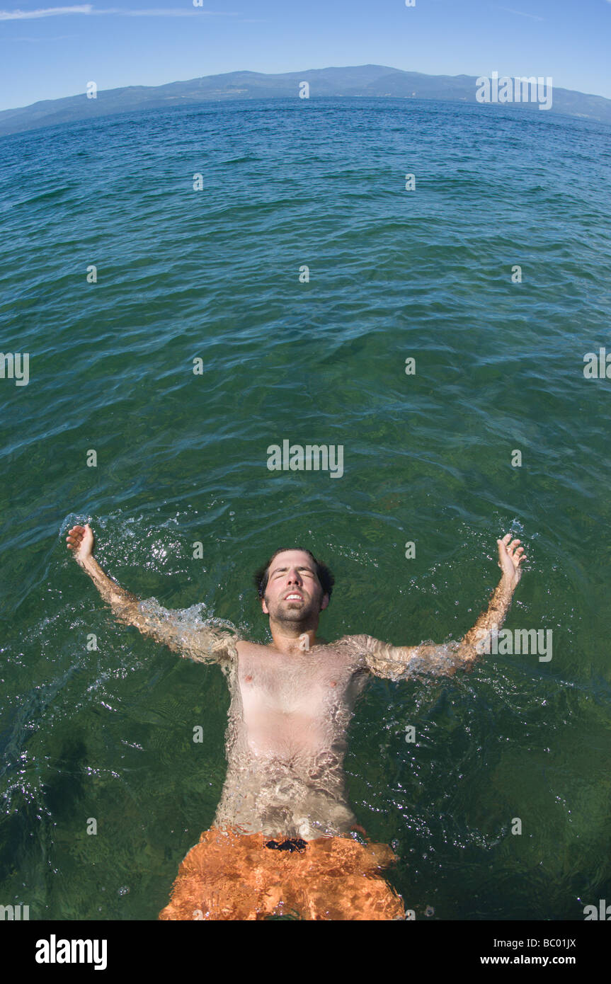 A young man floats on his back in a lake Stock Photo - Alamy