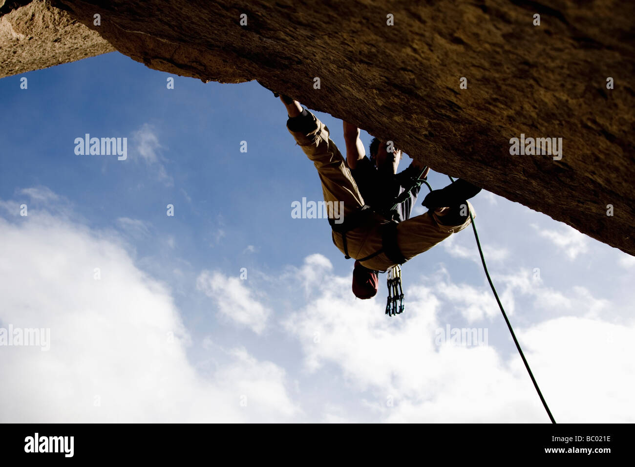 A rock climber makes his way through a difficult section of a climb ...