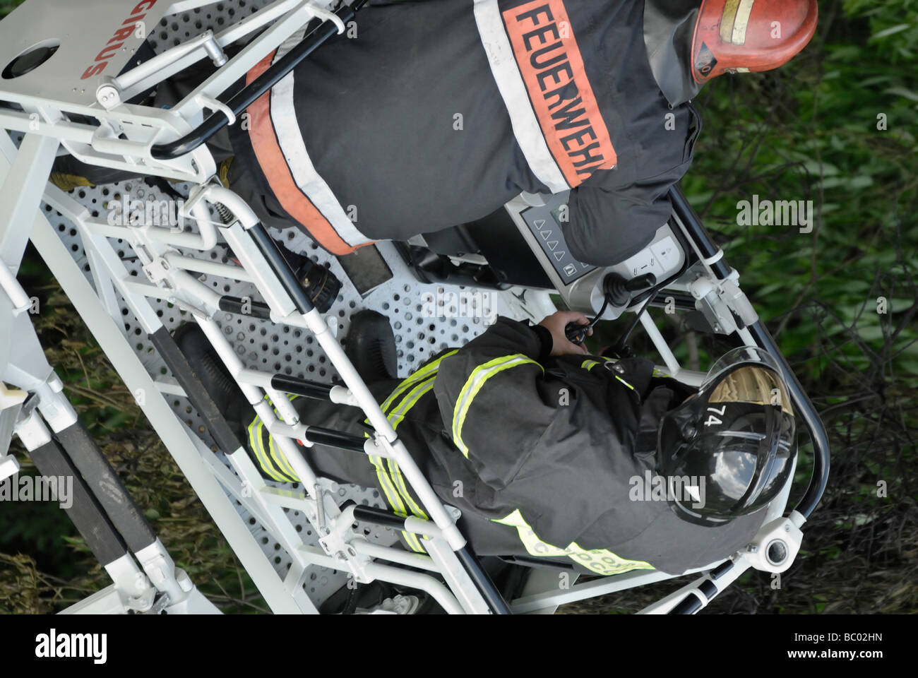 Two firemen in aerial platform of fire engine Stock Photo - Alamy