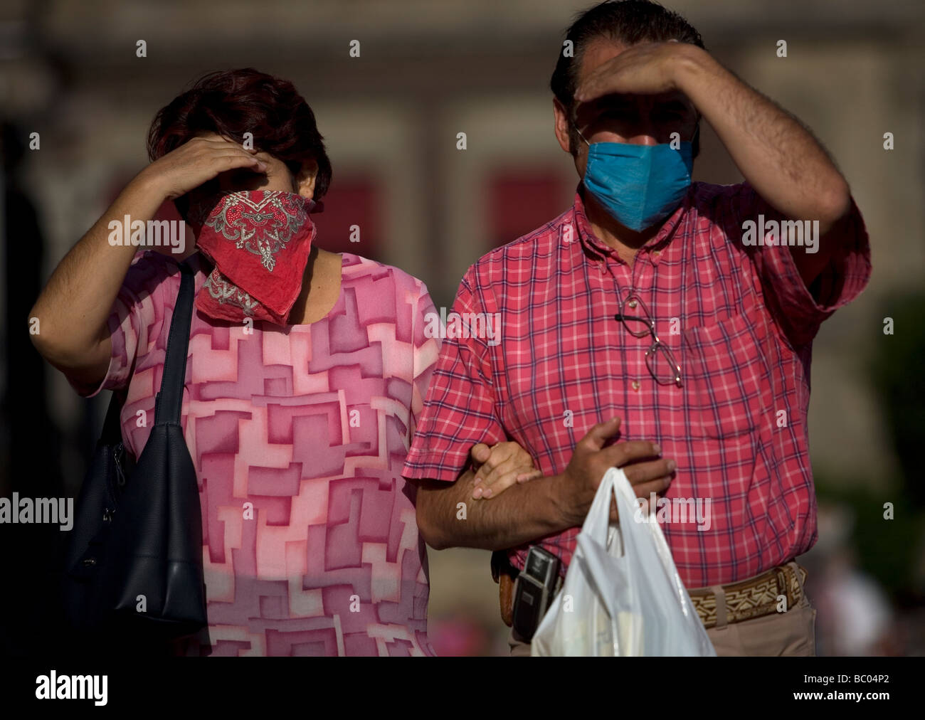 A couple wearing masks as a precaution against swine flu walk in Mexico ...