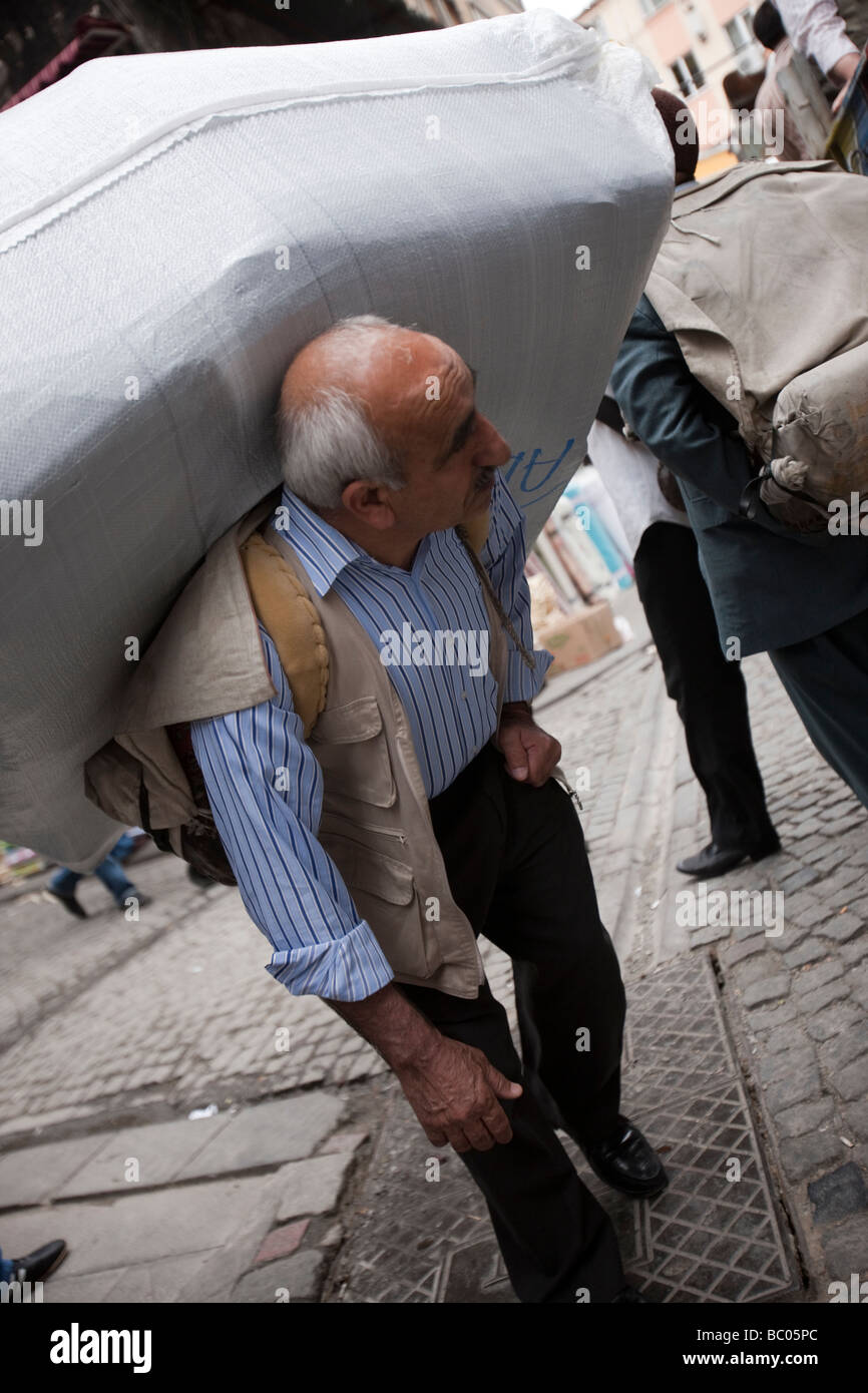 street photo of a turkish worker in Istanbul carrying a large package ...