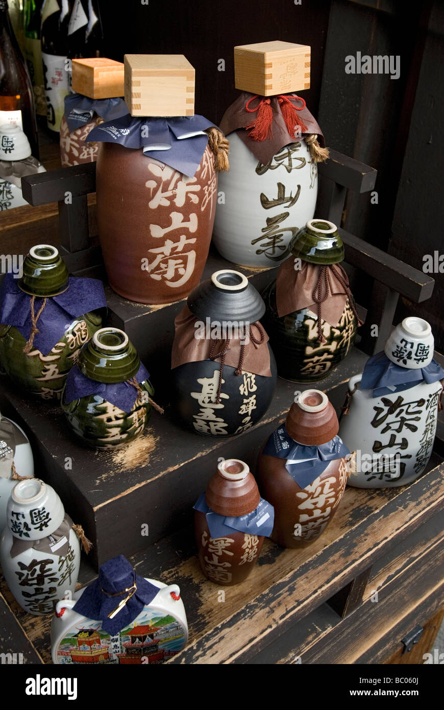 A collection of traditional tokkuri or sake wine jugs some with wooden ...
