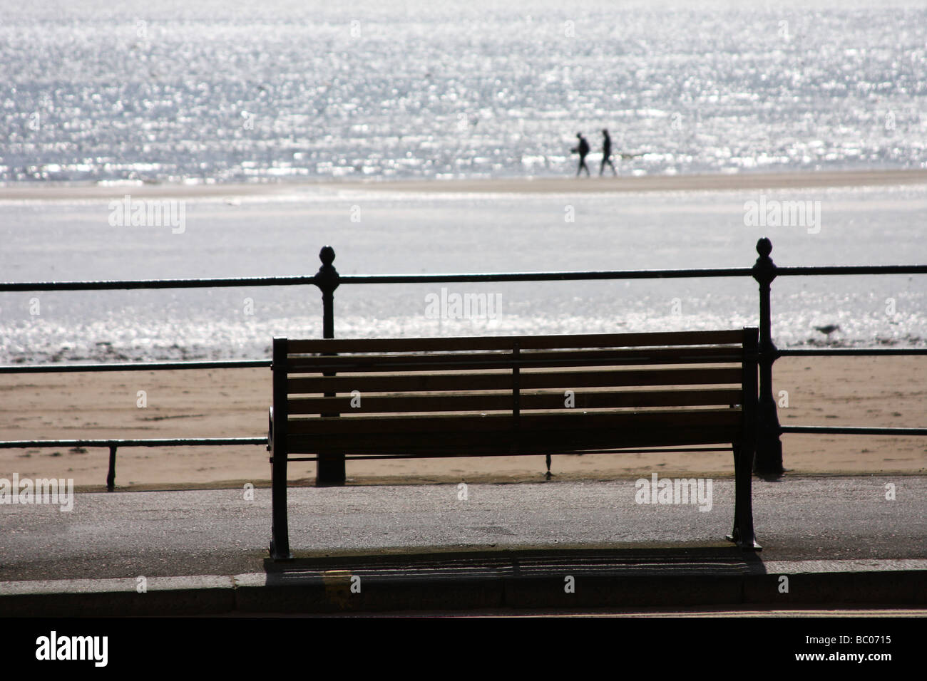 Empty seafront bench on seafront in Scarborough with couple in ...