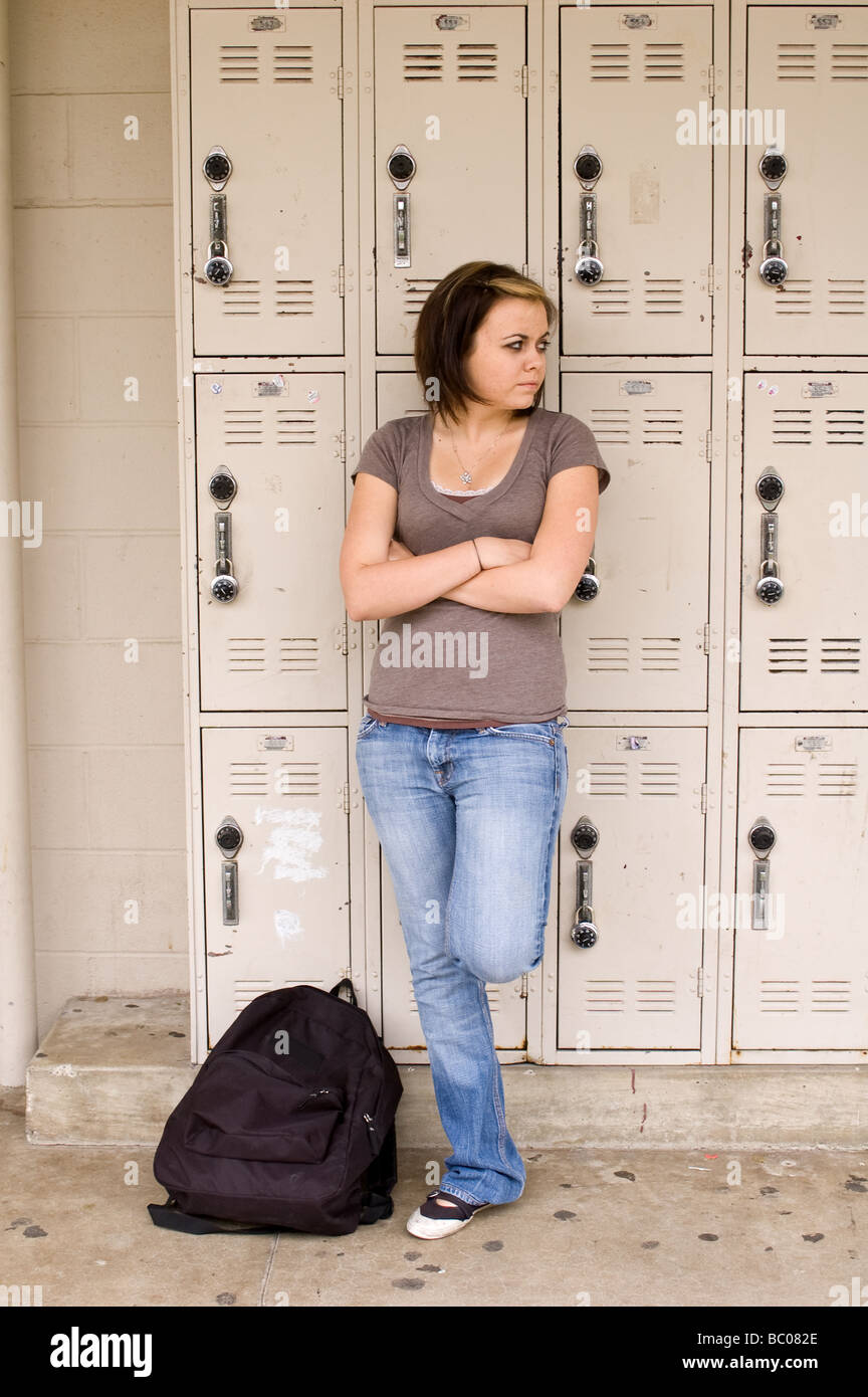 A teen ager with a disgusted look on her face waits for her friend to ...