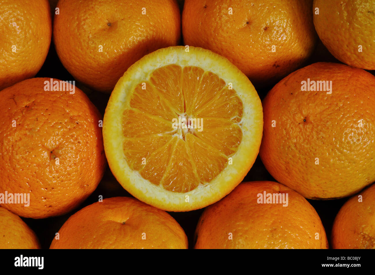 Many Orange fruits with one Orange cut in half for display Stock Photo ...