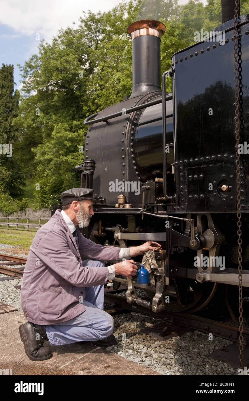 Volunteer Narrow Gauge steam engine driver carefully oils/lubricates ...