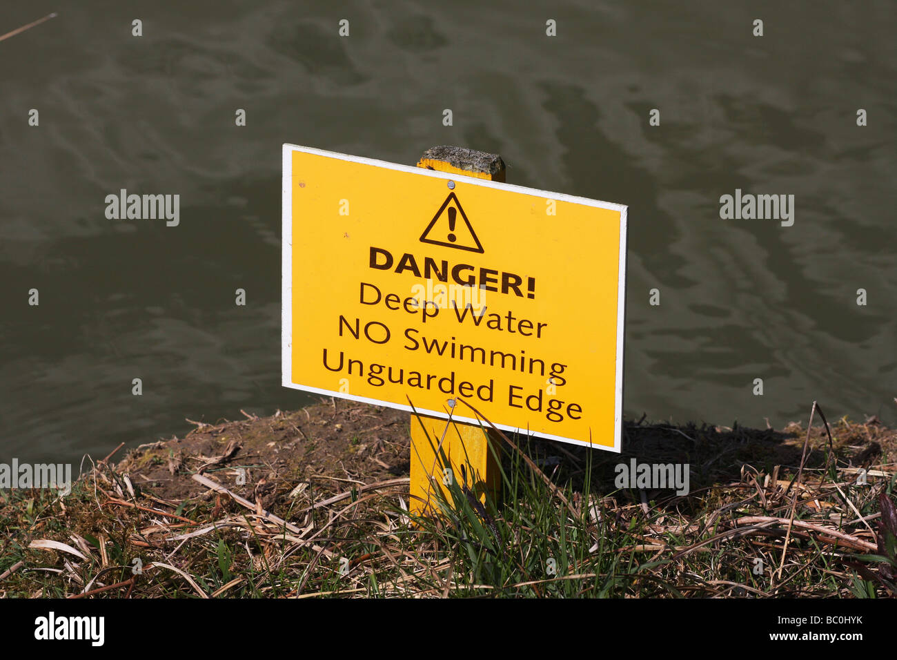 Danger warning sign for deep water and unguarded edge Stock Photo - Alamy
