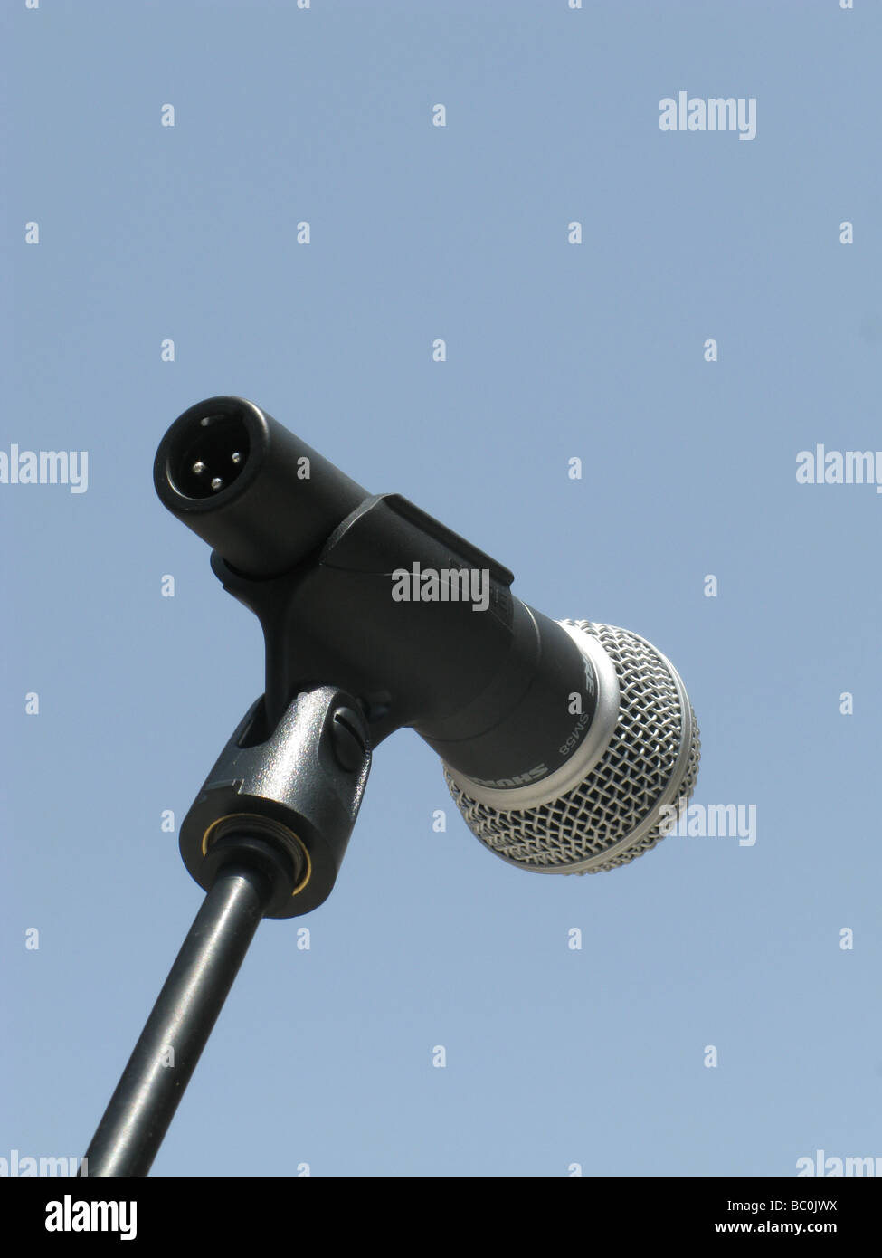 one microphone outdoors at event with blue sky Stock Photo - Alamy