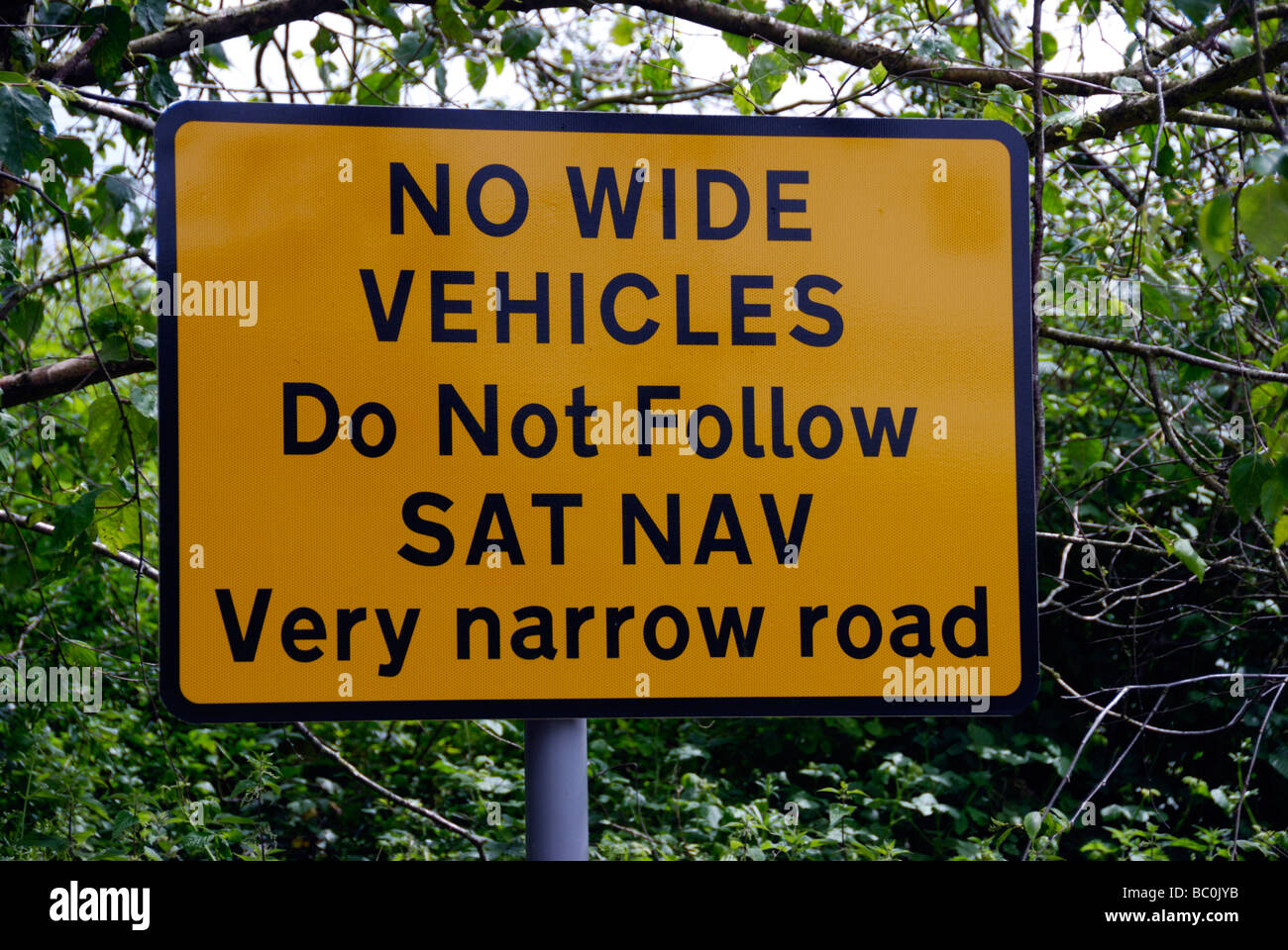 Road sign on very narrow road prohibiting wide vehicles and asking ...