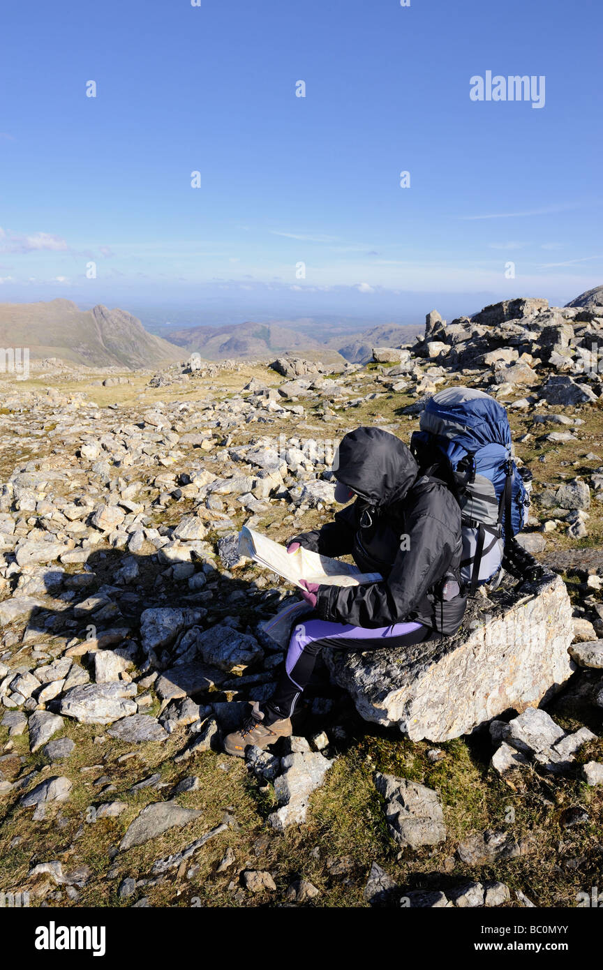A female walker reading a map on the summit of Allen Crag, Seathwaite ...