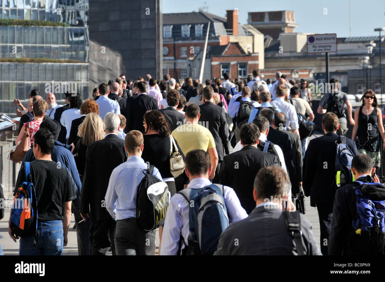 Office workers walking across bridge towards London Bridge railway ...