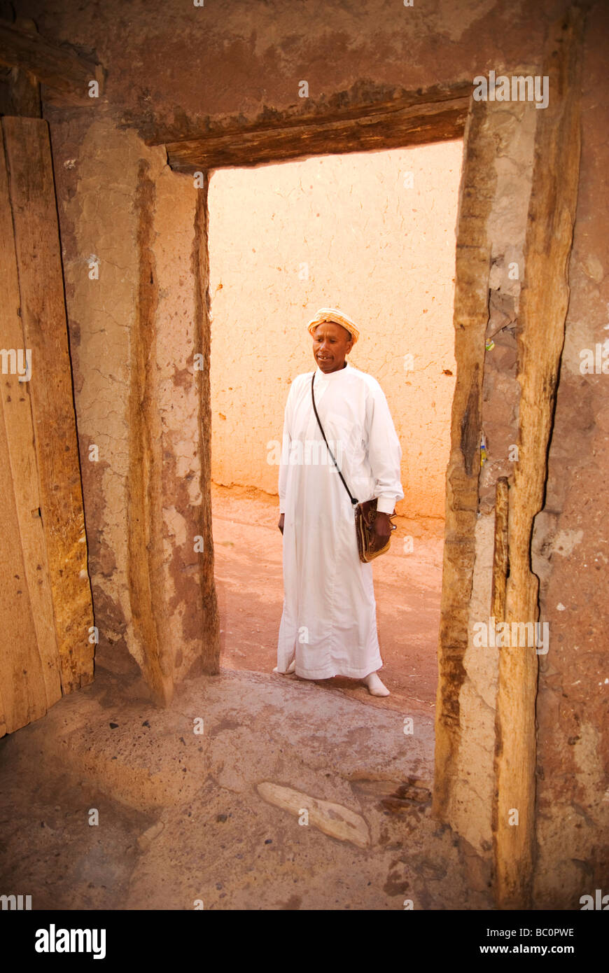 A Moroccan man in traditional dress stands in the doorway of a Moroccan ...