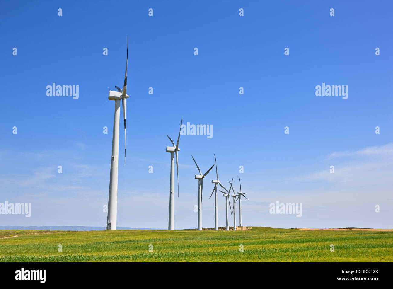 Wind turbines farm in green field over cloudy sky Stock Photo - Alamy