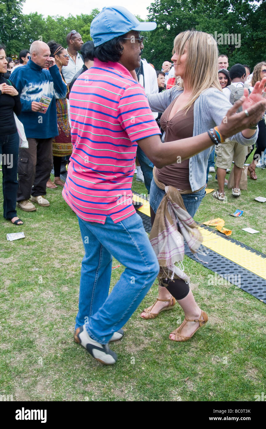 UK. Couple of mixed race dancing latin salsa at a funfair in London ...