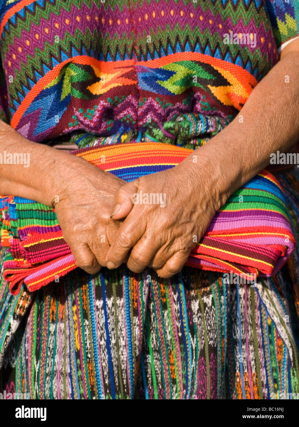 The hands of an indigenous Guatemalan woman holding traditional fabric ...
