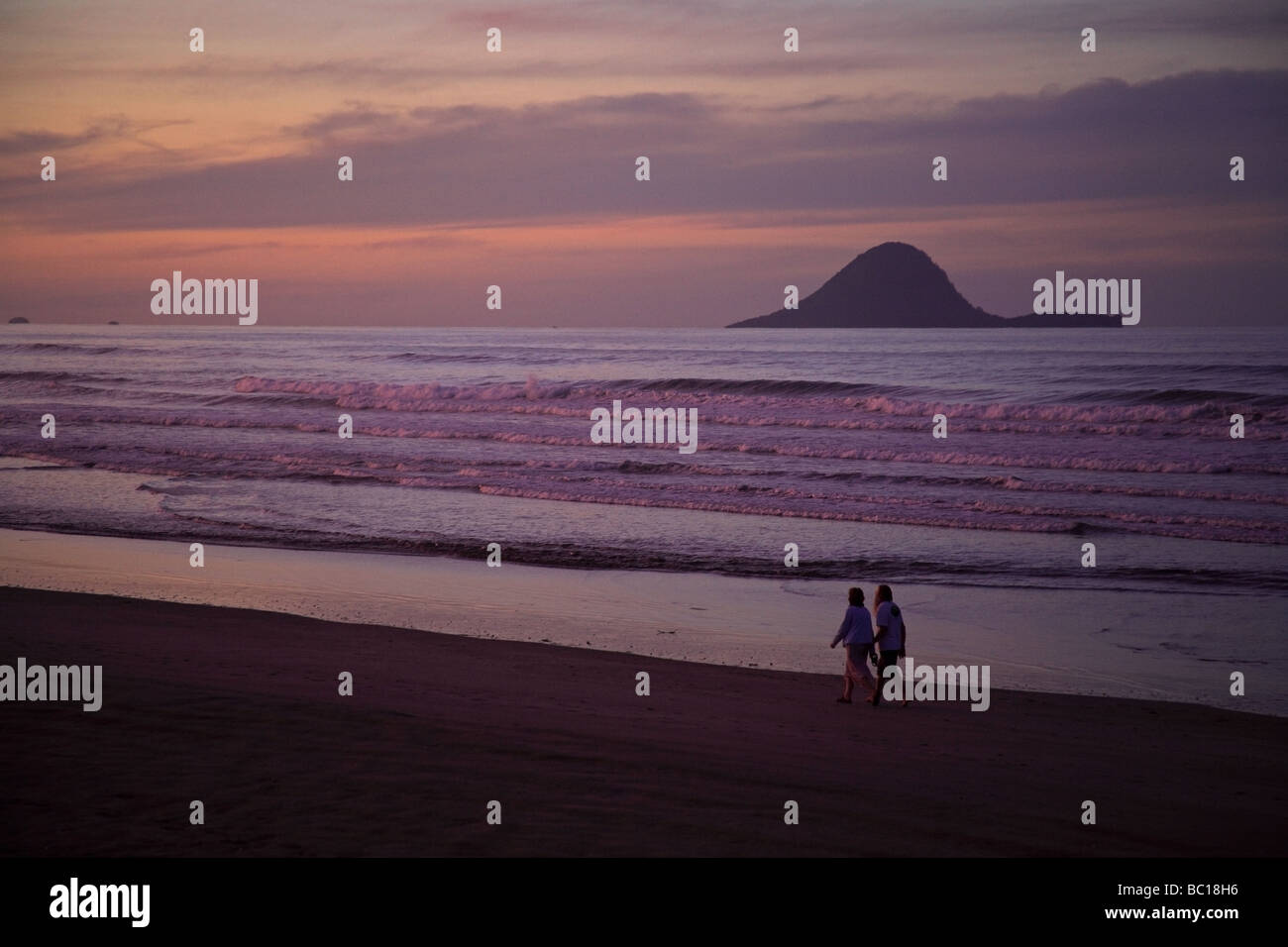 People walking on the beach at sunset Stock Photo - Alamy
