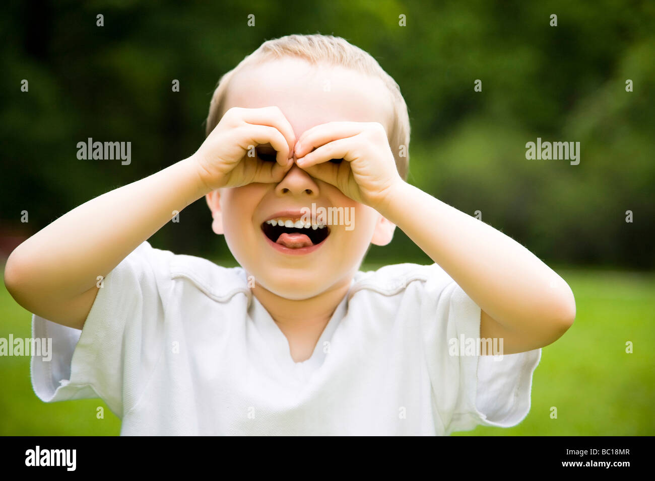 Searching Little Boy On A Meadow Stock Photo - Alamy