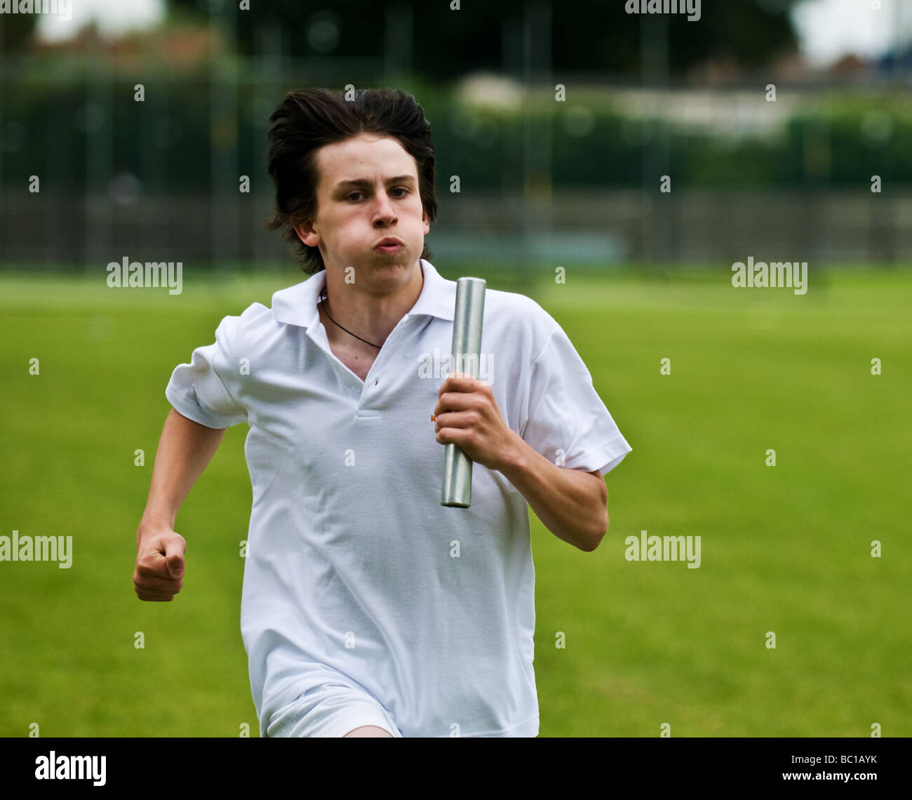 An athletics student running in a relay race Stock Photo - Alamy