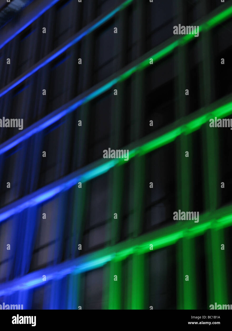 modern office block front illuminated with colourful lights at night ...