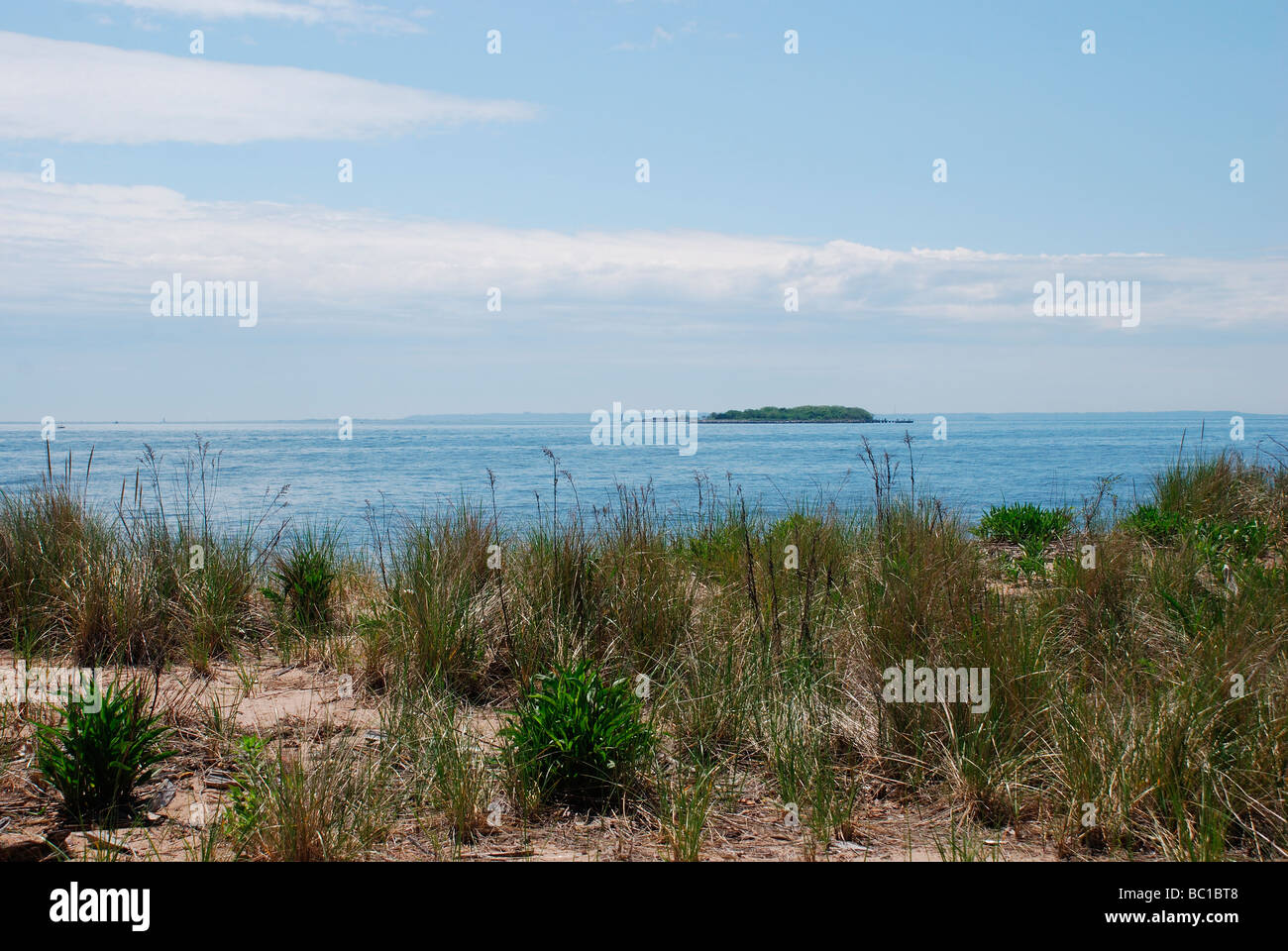 remote beach on ocean shore with small island in the distance on a ...