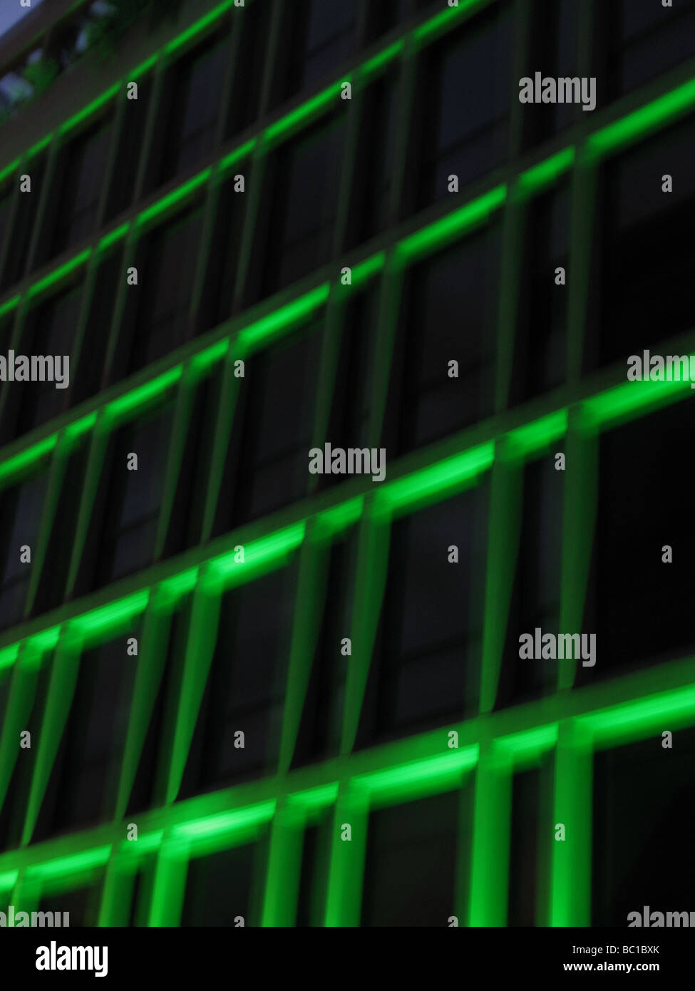 modern office block front illuminated with colourful lights at night ...
