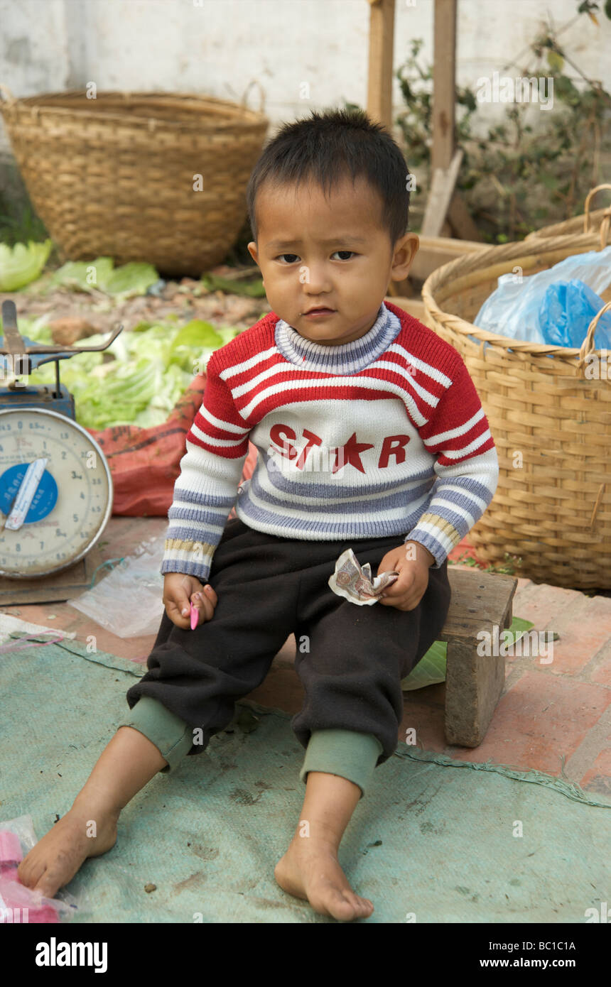 The small child of a market stall holder in Luang Prabang's daily fresh ...